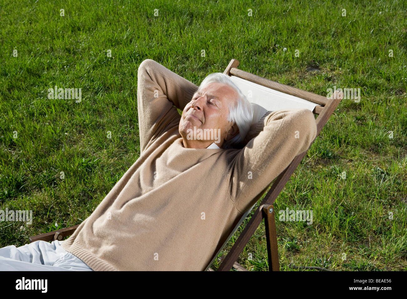 A senior man reclining in a lounge chair on a lawn Stock Photo - Alamy