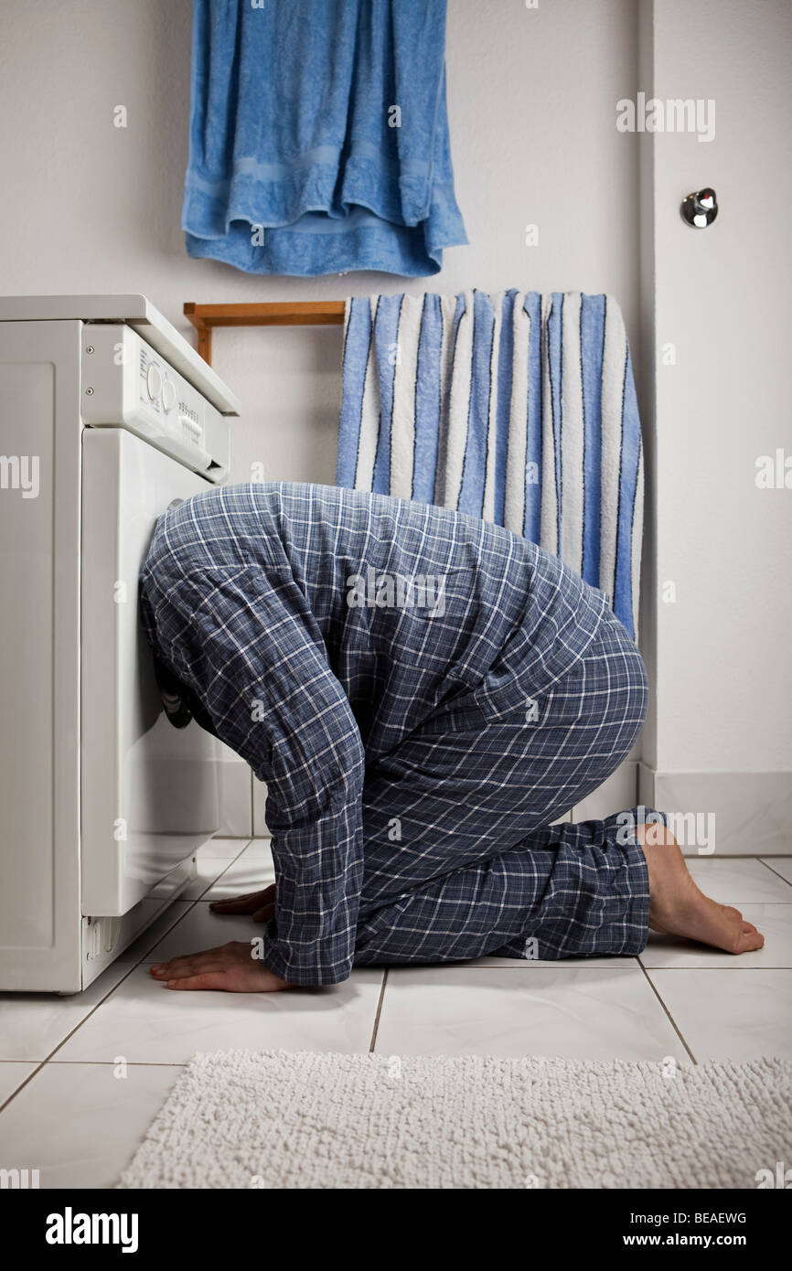 A man wearing pajamas with his head inside a washing machine Stock ...