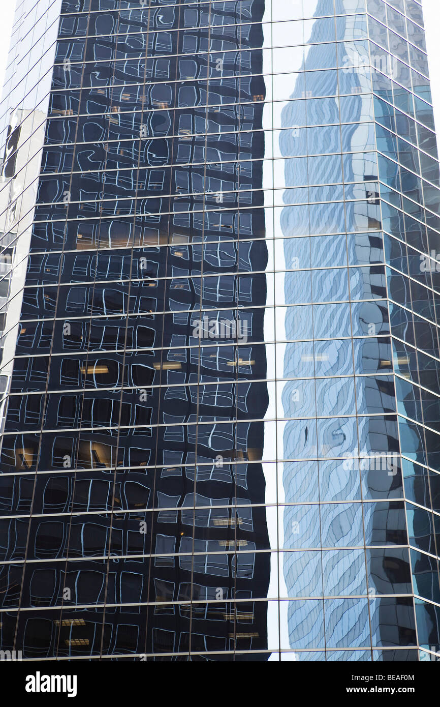 Skyscraper with distorted reflection of buildings, Manhattan, New York ...
