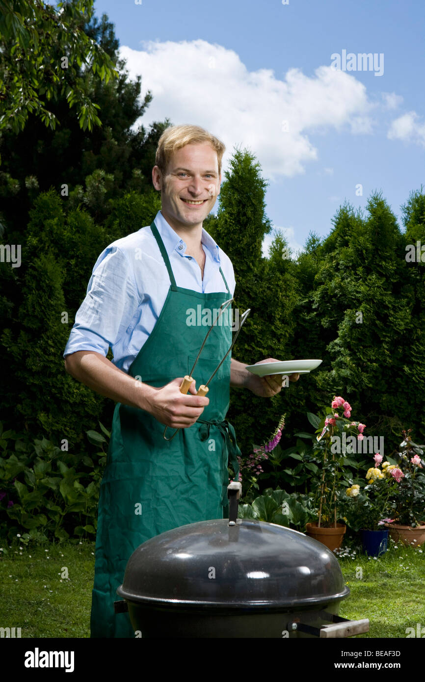 A man barbecuing in a back yard Stock Photo - Alamy