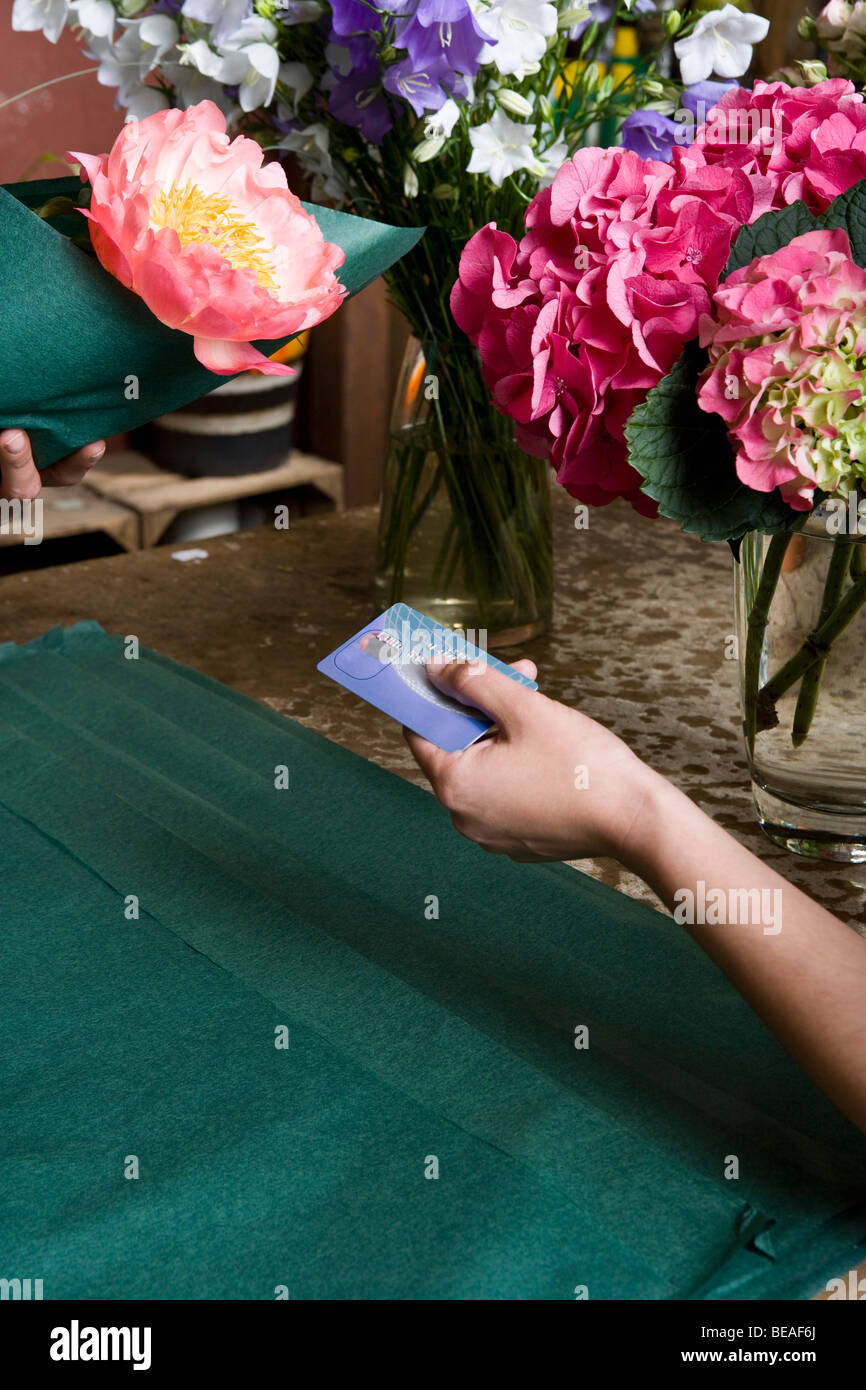 A person paying for flowers in a florists Stock Photo - Alamy