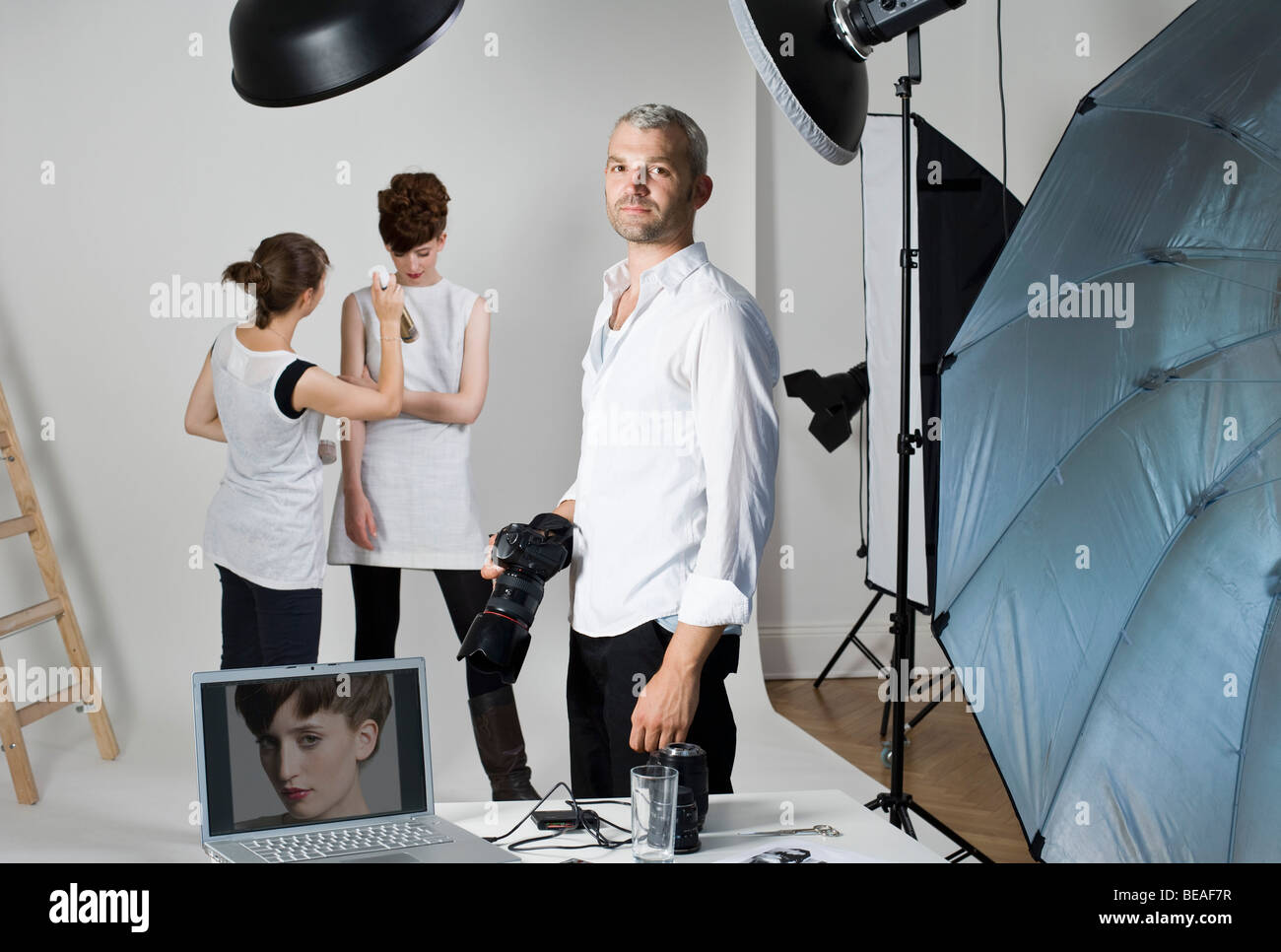 A photographer, model and make-up artist on set of a fashion shoot ...