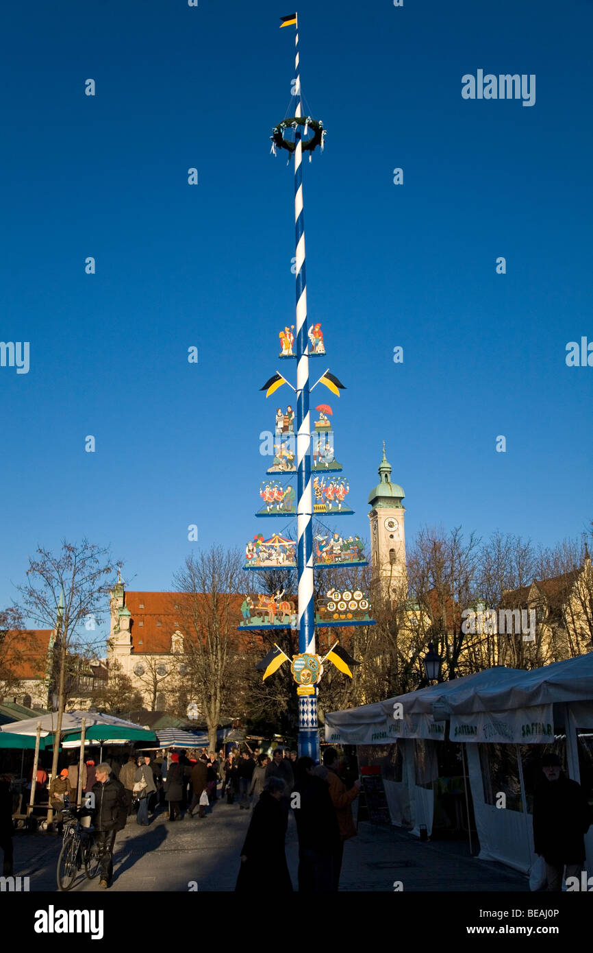 A Maypole towers above the shaded Viktualienmarkt in Munich, Germany ...