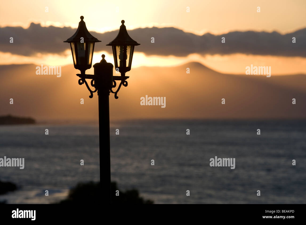Yellow sunset with clouds and streetlights on the island of Crete ...