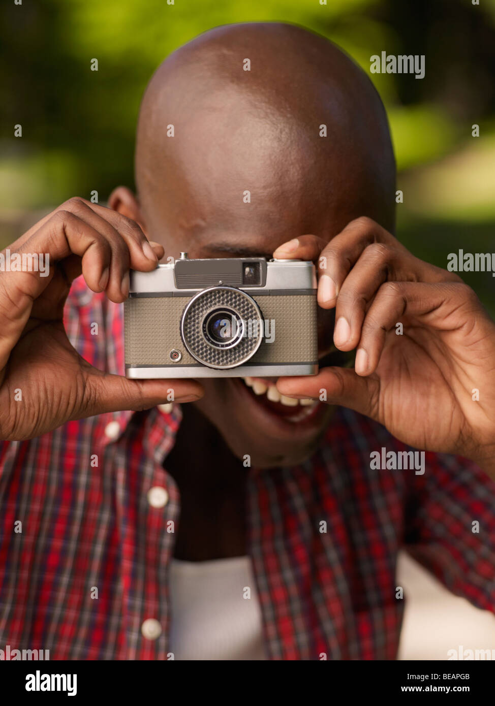 African man taking photograph with retro camera Stock Photo - Alamy