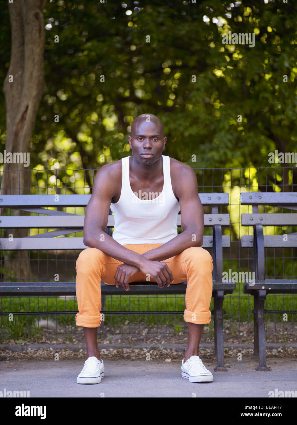 Serious African man sitting on bench Stock Photo - Alamy
