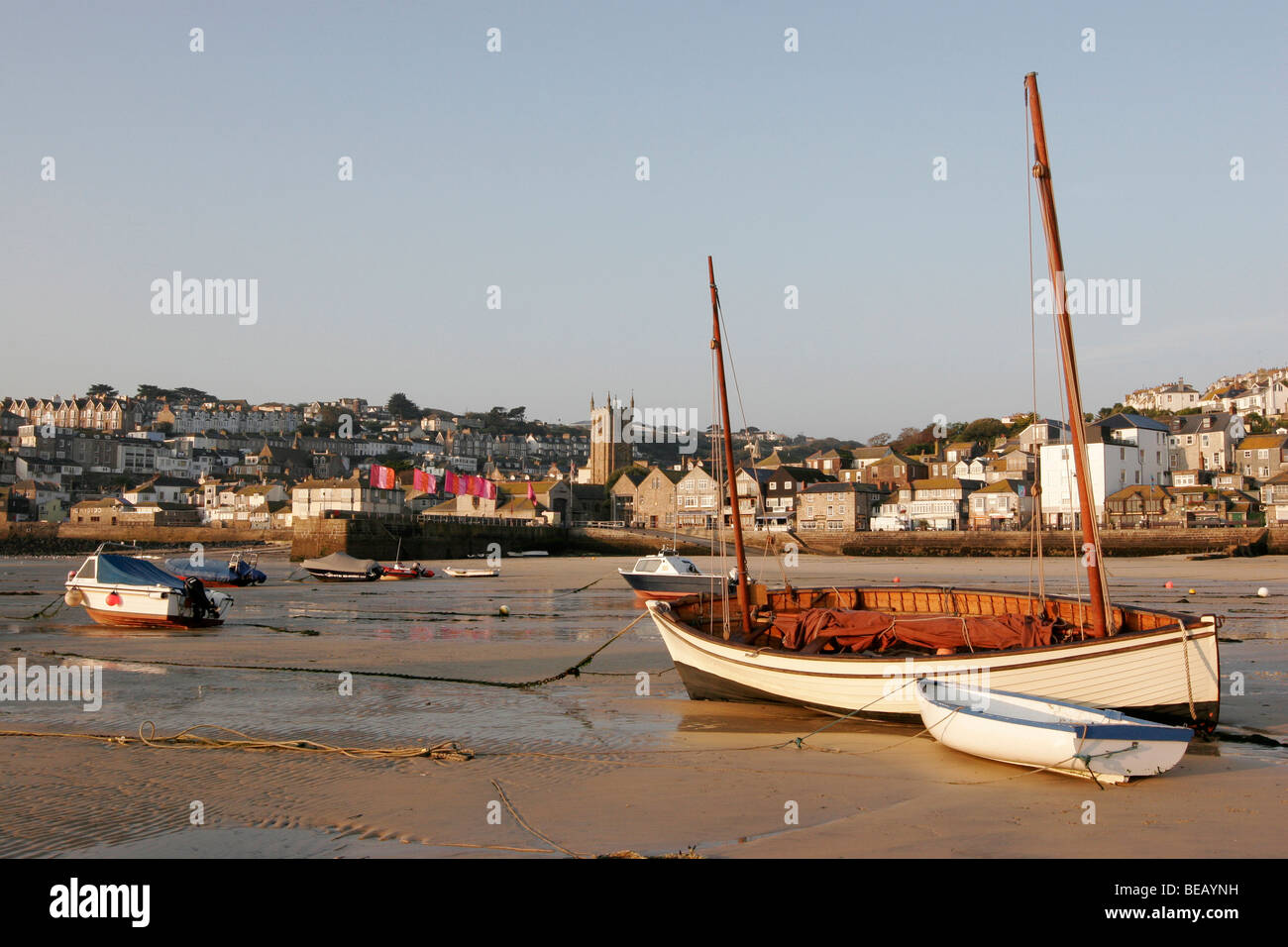 The Harbour at St Ives in Cornwall at low tide with the flags flying in ...