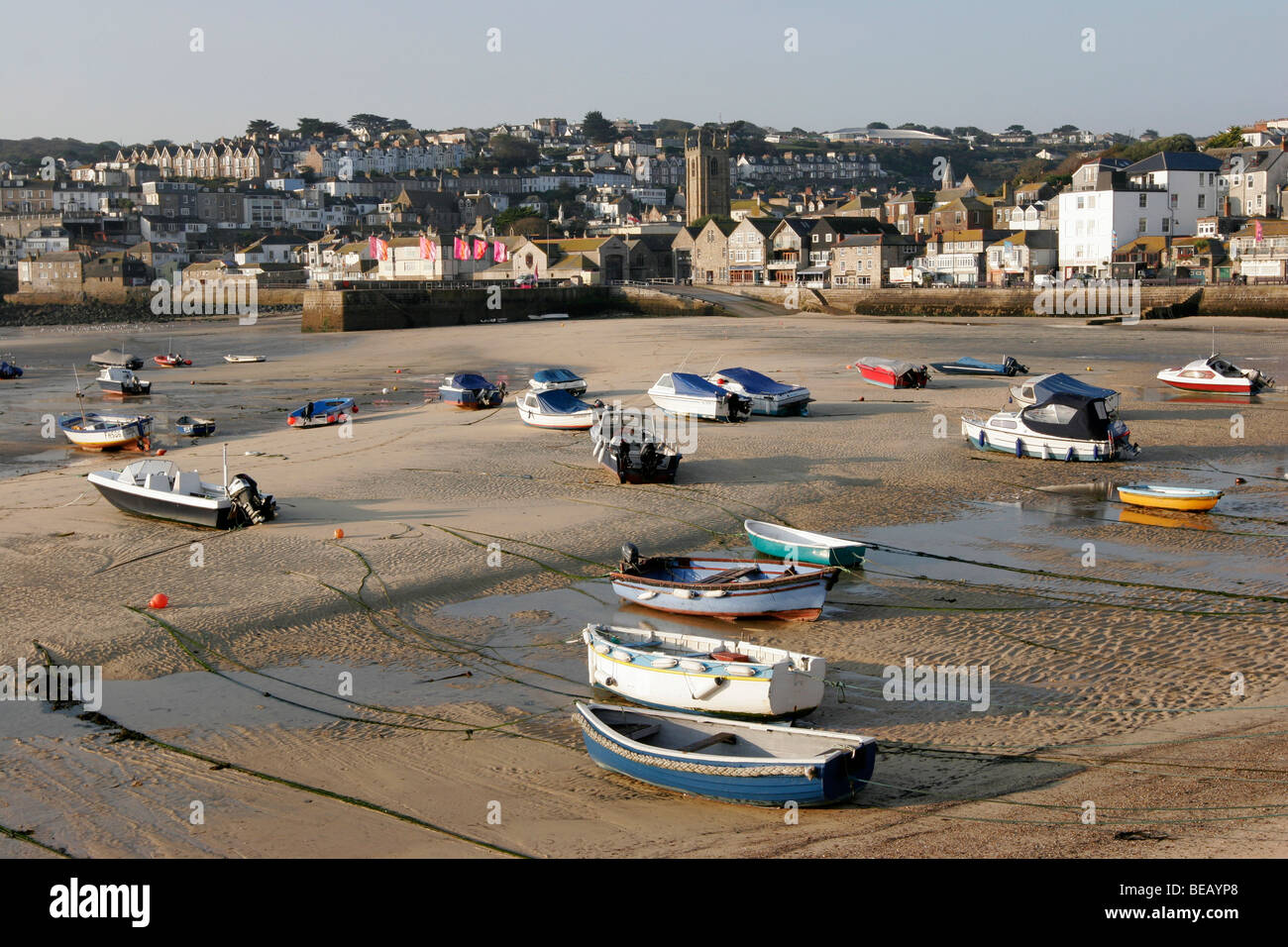 The Harbour at St Ives in Cornwall at low tide with the flags flying in ...