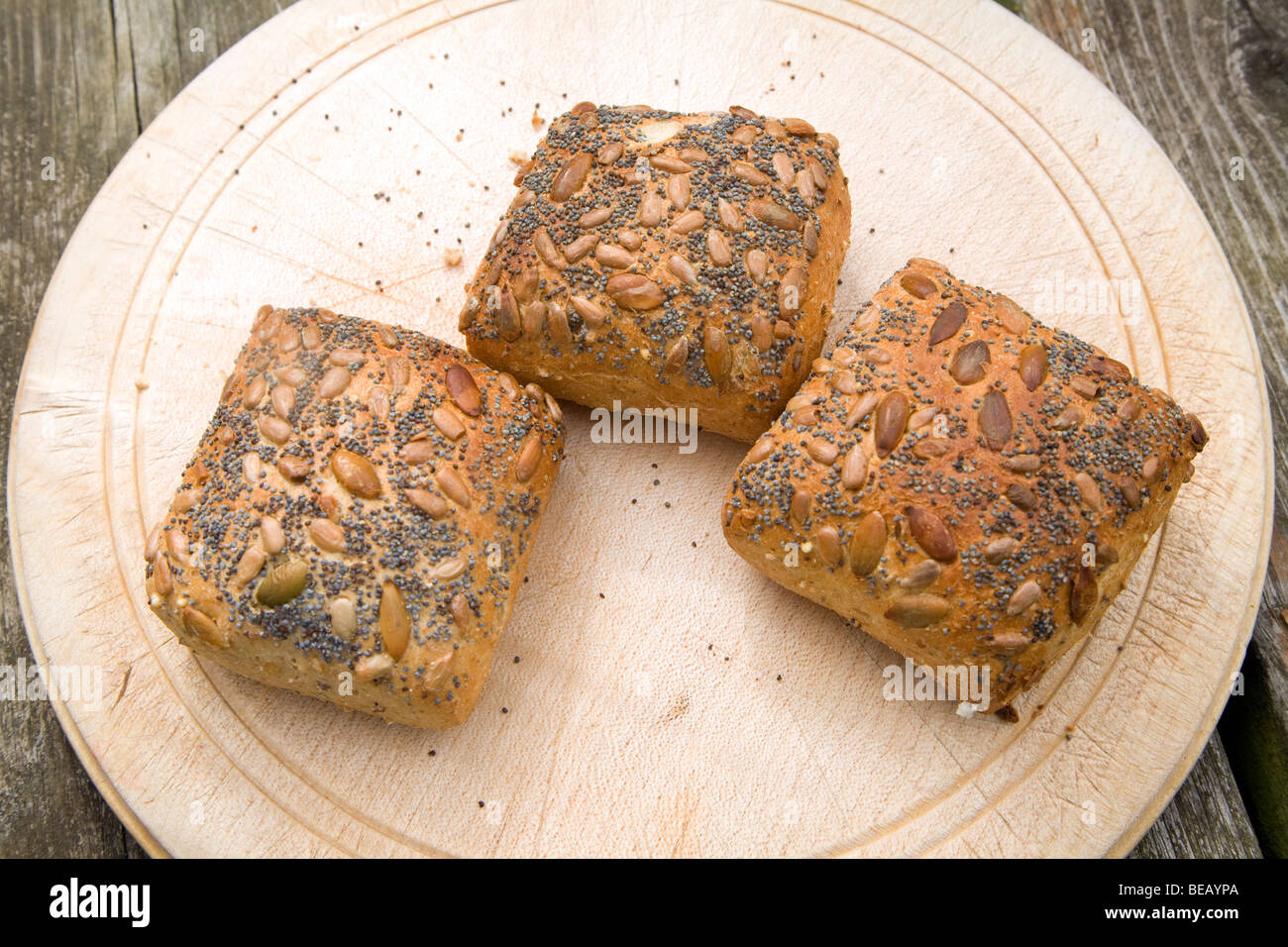 Three bread rolls with seeds on board Stock Photo - Alamy