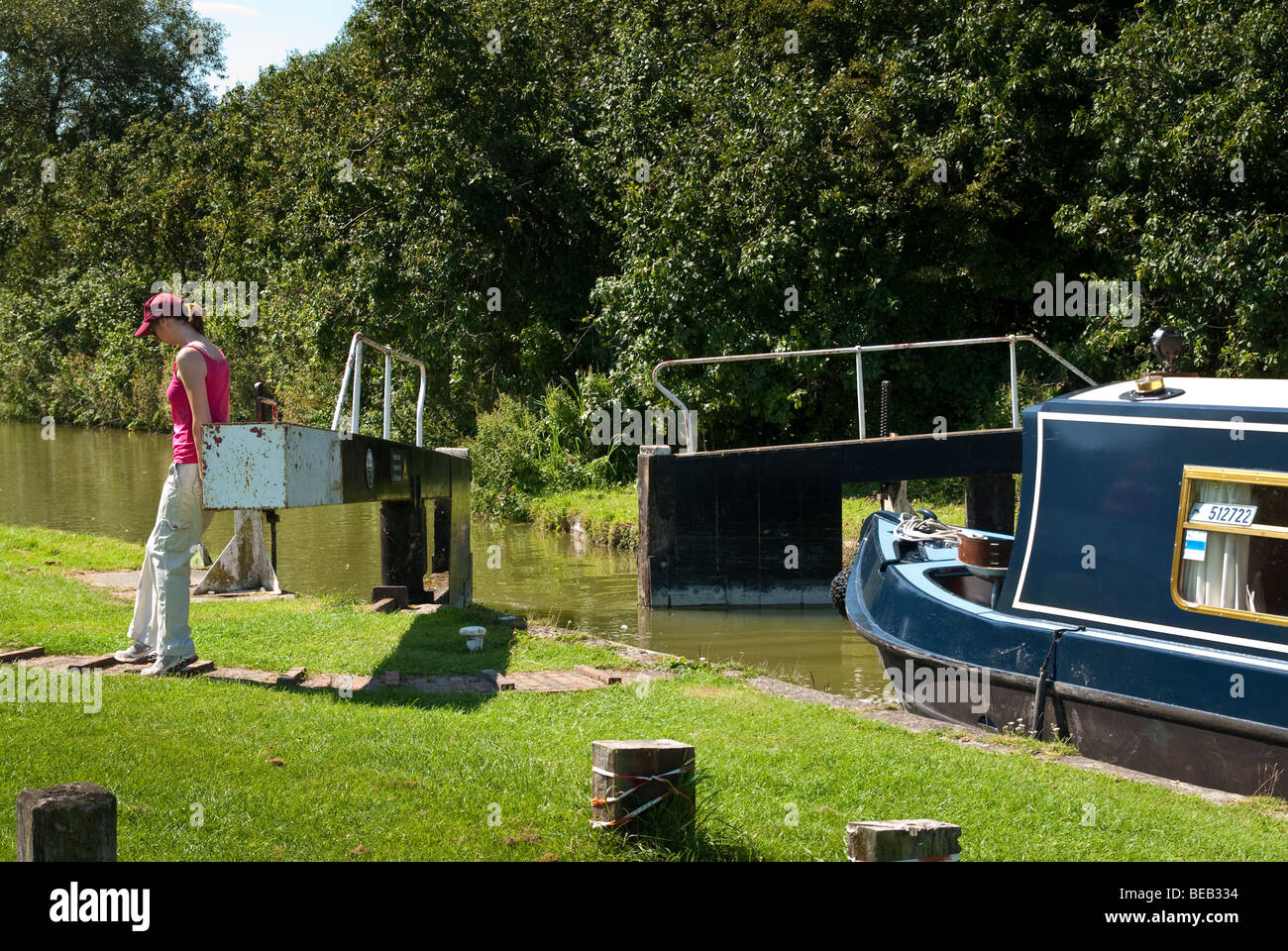 One girl opens lock gate as two narrow boats going through lock 68 ...