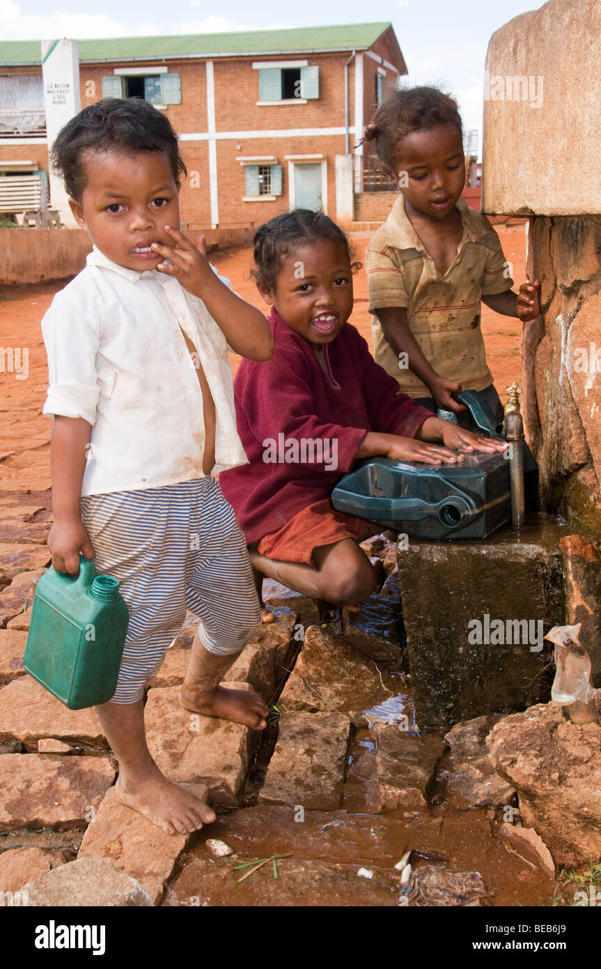 children filling their water jugs at a community tap in Ambalavao in ...