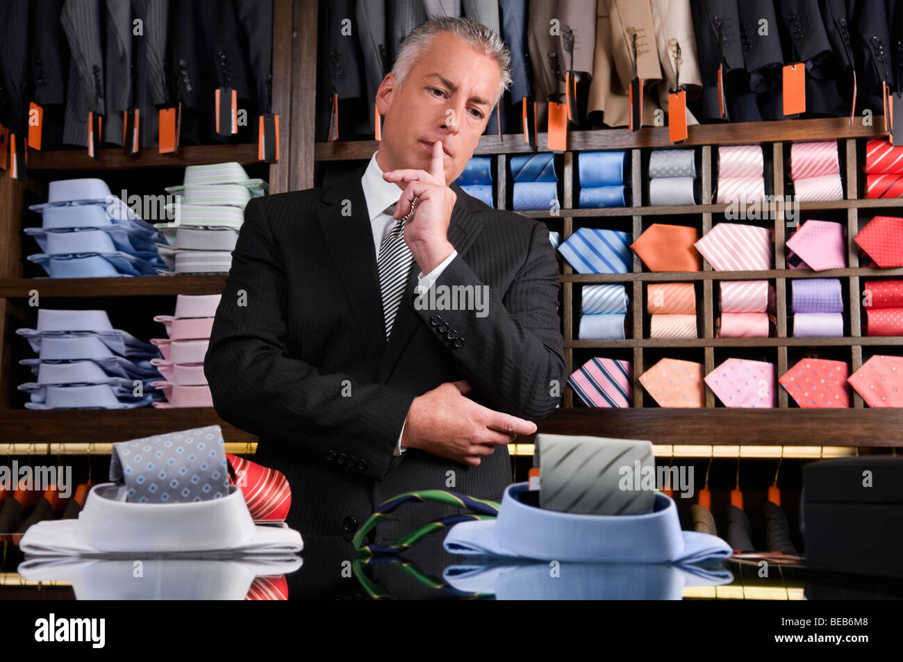 Customer thinking in a clothing store Stock Photo - Alamy