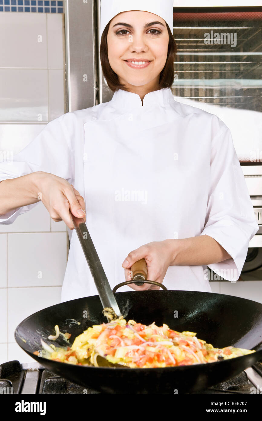 Female chef cooking food in the kitchen Stock Photo - Alamy