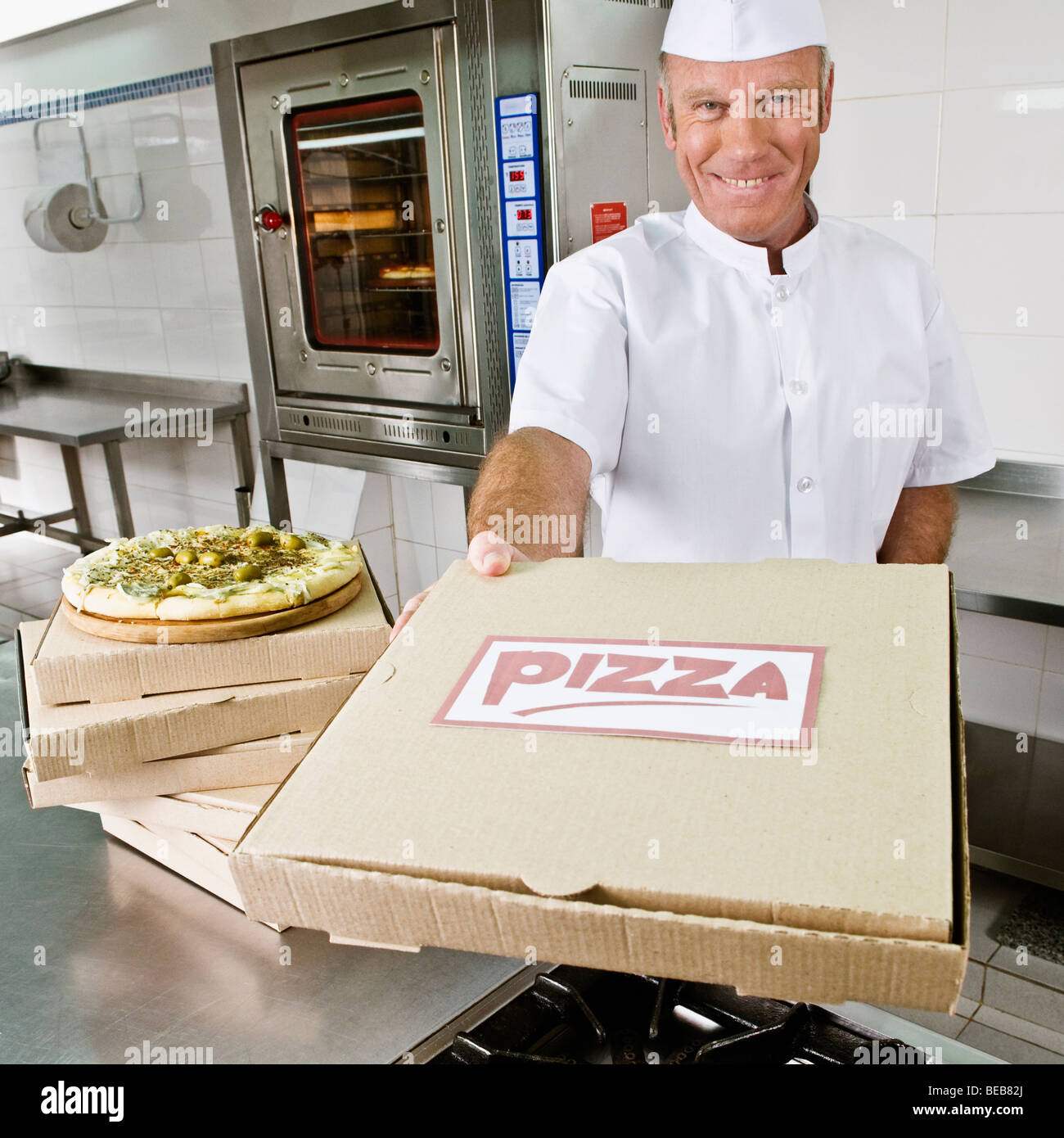Chef holding a pizza box Stock Photo - Alamy