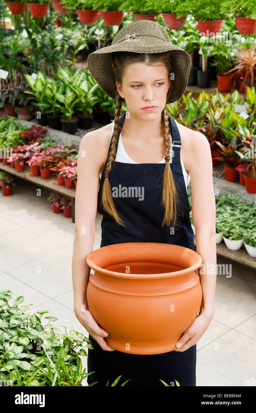 Woman holding a pot in a greenhouse Stock Photo - Alamy