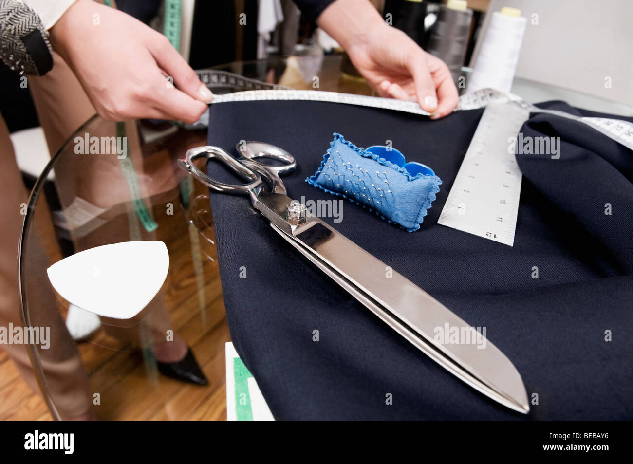 Female tailor taking measurement in a clothing store Stock Photo - Alamy
