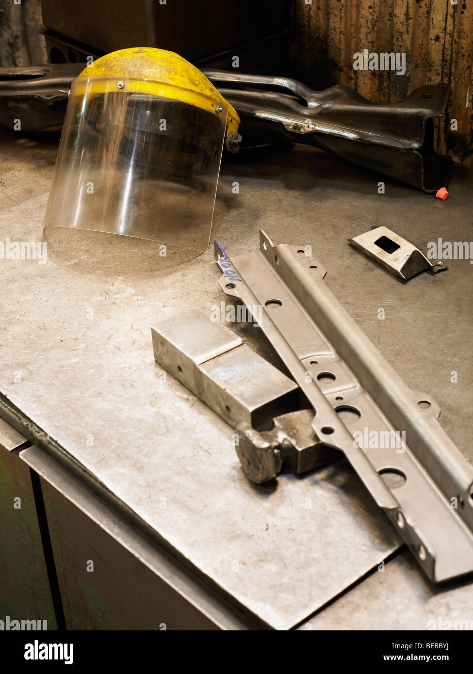 Close-up of a metal object and a helmet visor on a workbench Stock ...