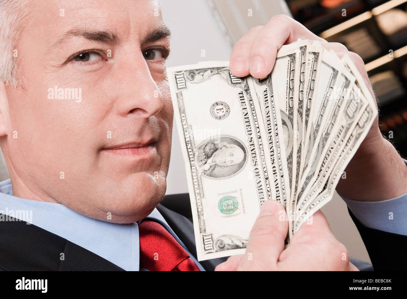 Businessman holding currency notes in a clothing store Stock Photo - Alamy
