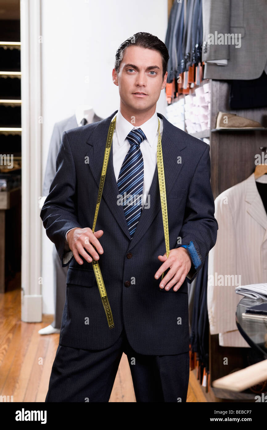 Portrait of a tailor holding a tape measure Stock Photo - Alamy