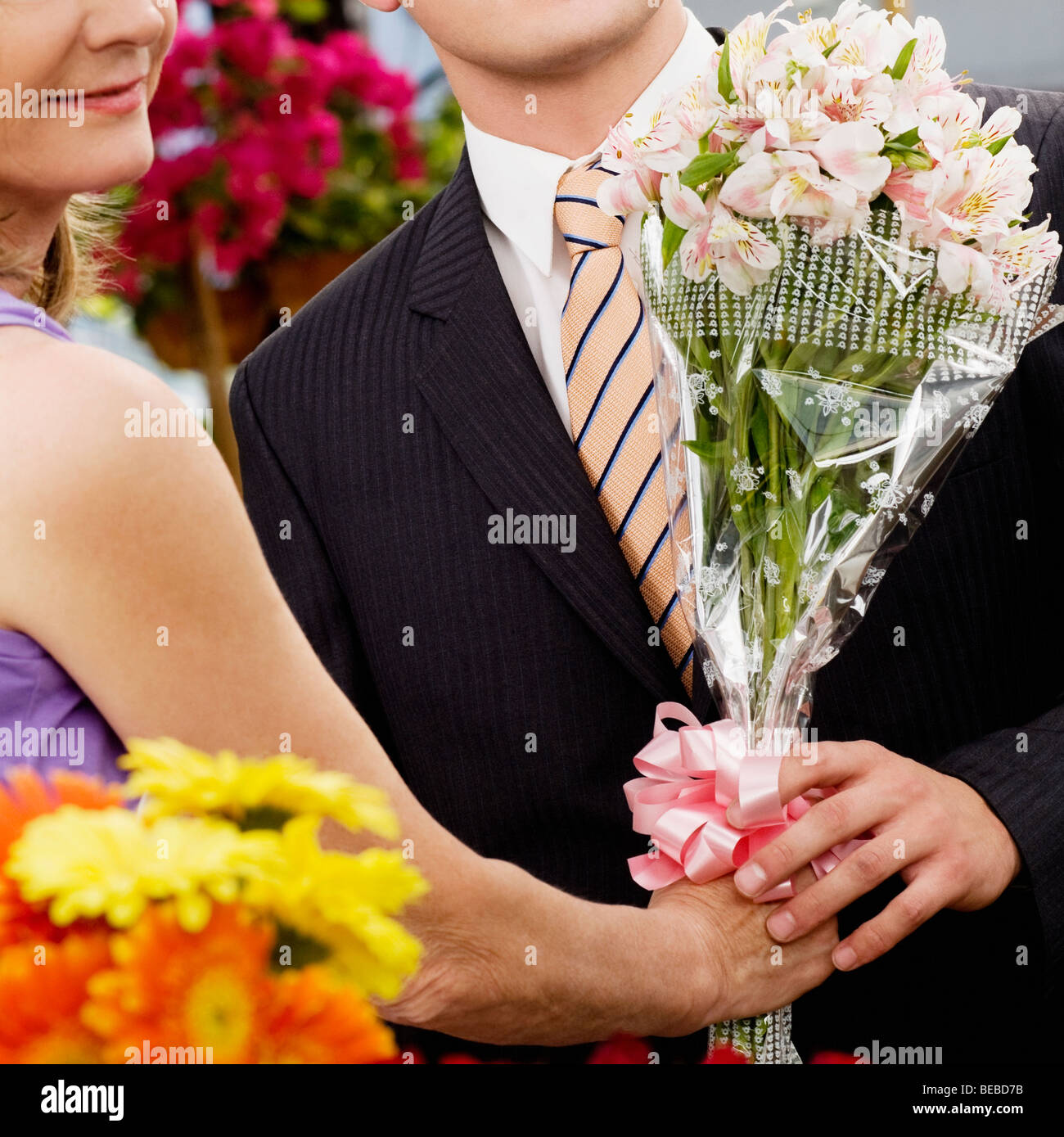 Female florist giving a bouquet of flowers to a customer Stock Photo ...