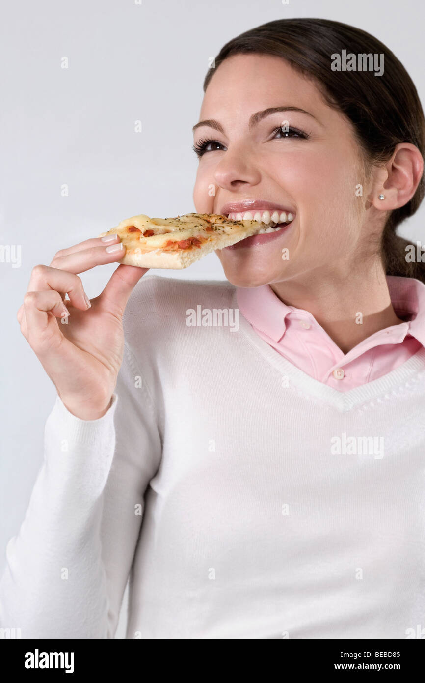 Female chef eating a slice of pizza Stock Photo - Alamy