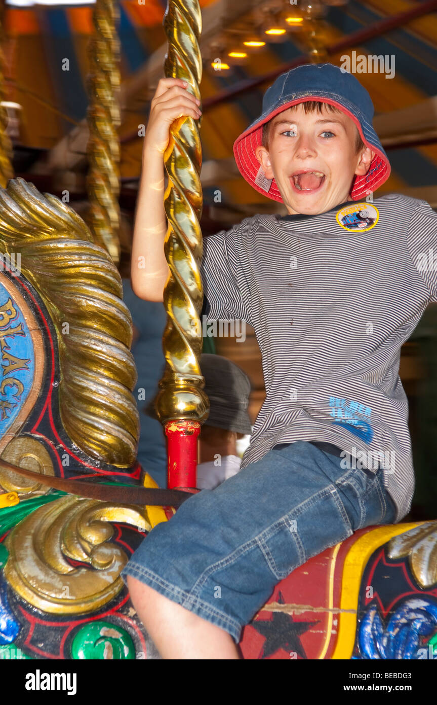 A young boy rides on The Victorian Gallopers Roundabout carousel at ...