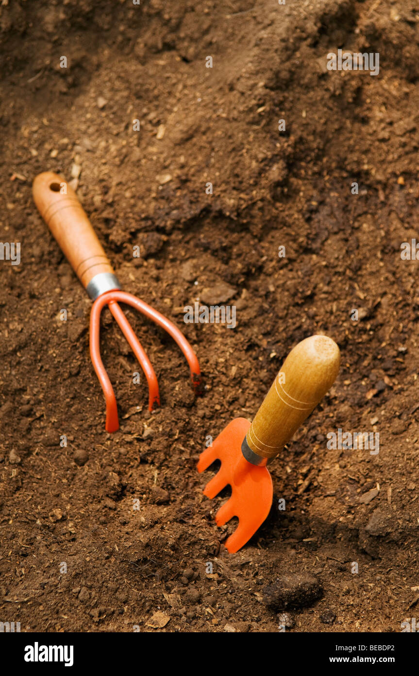 Gardening fork and rake in compost Stock Photo - Alamy