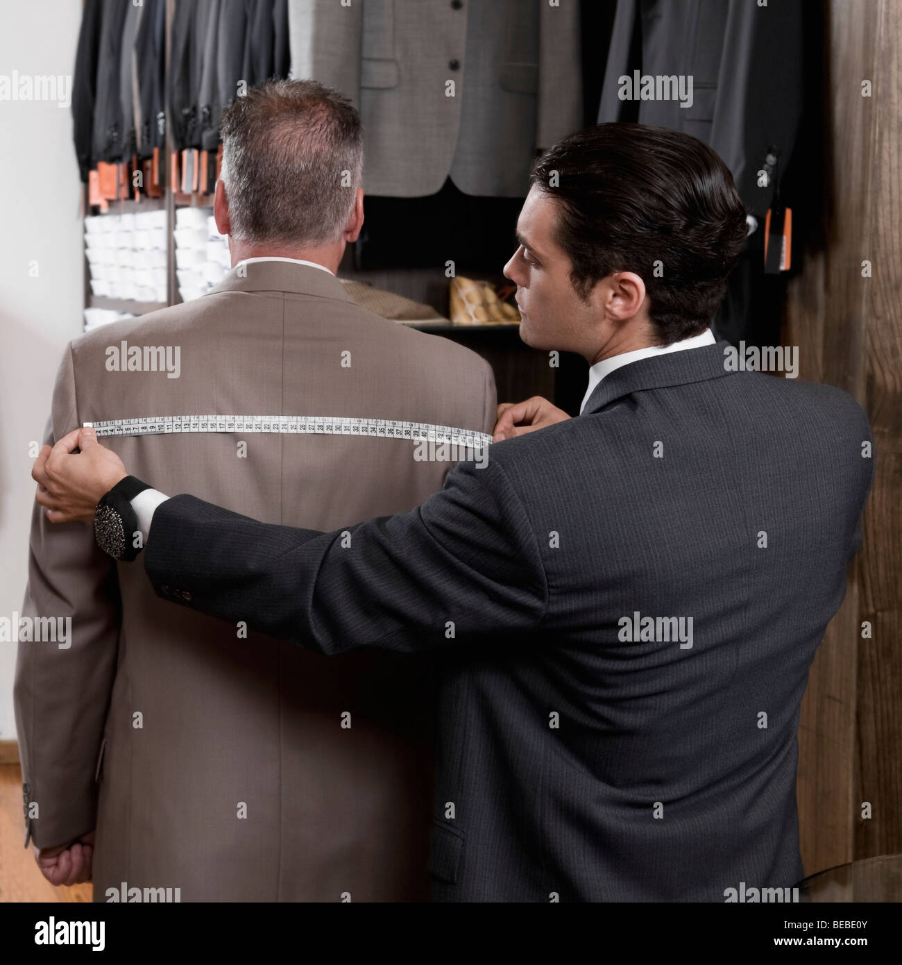 Tailor taking the measurements of a customer Stock Photo - Alamy