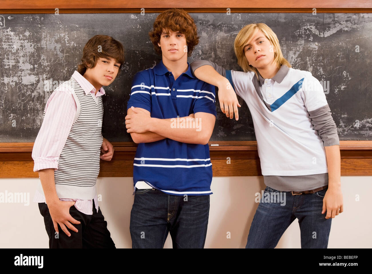 Three students standing in front of a blackboard Stock Photo - Alamy