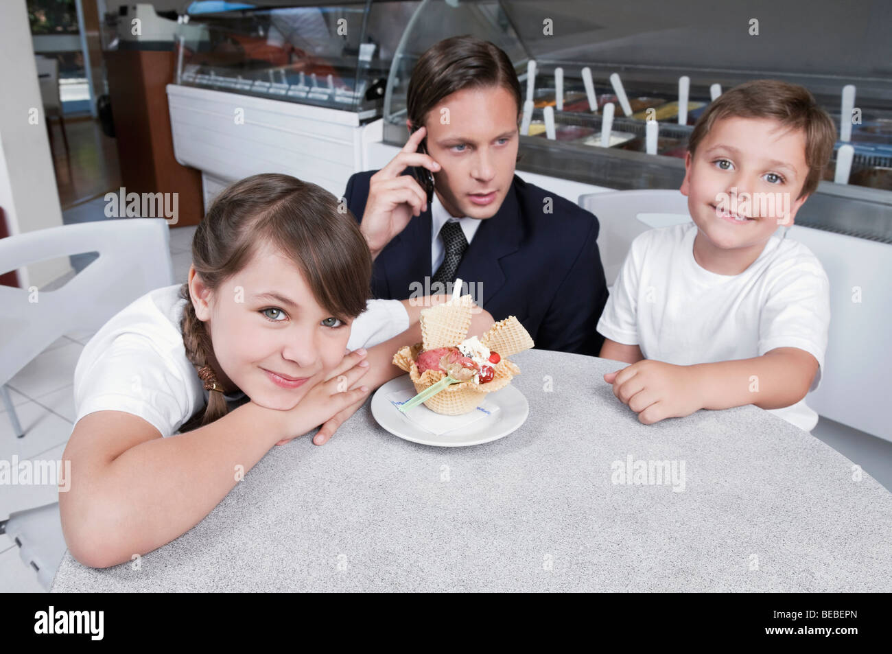 Man with his two children in an ice cream parlor Stock Photo - Alamy