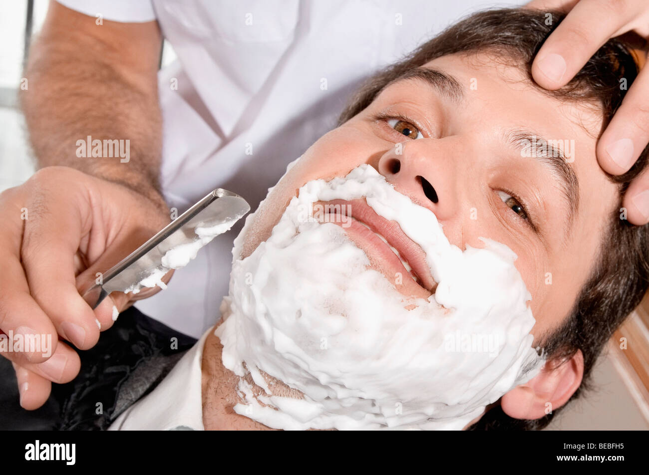 Man getting shaved in a salon Stock Photo - Alamy