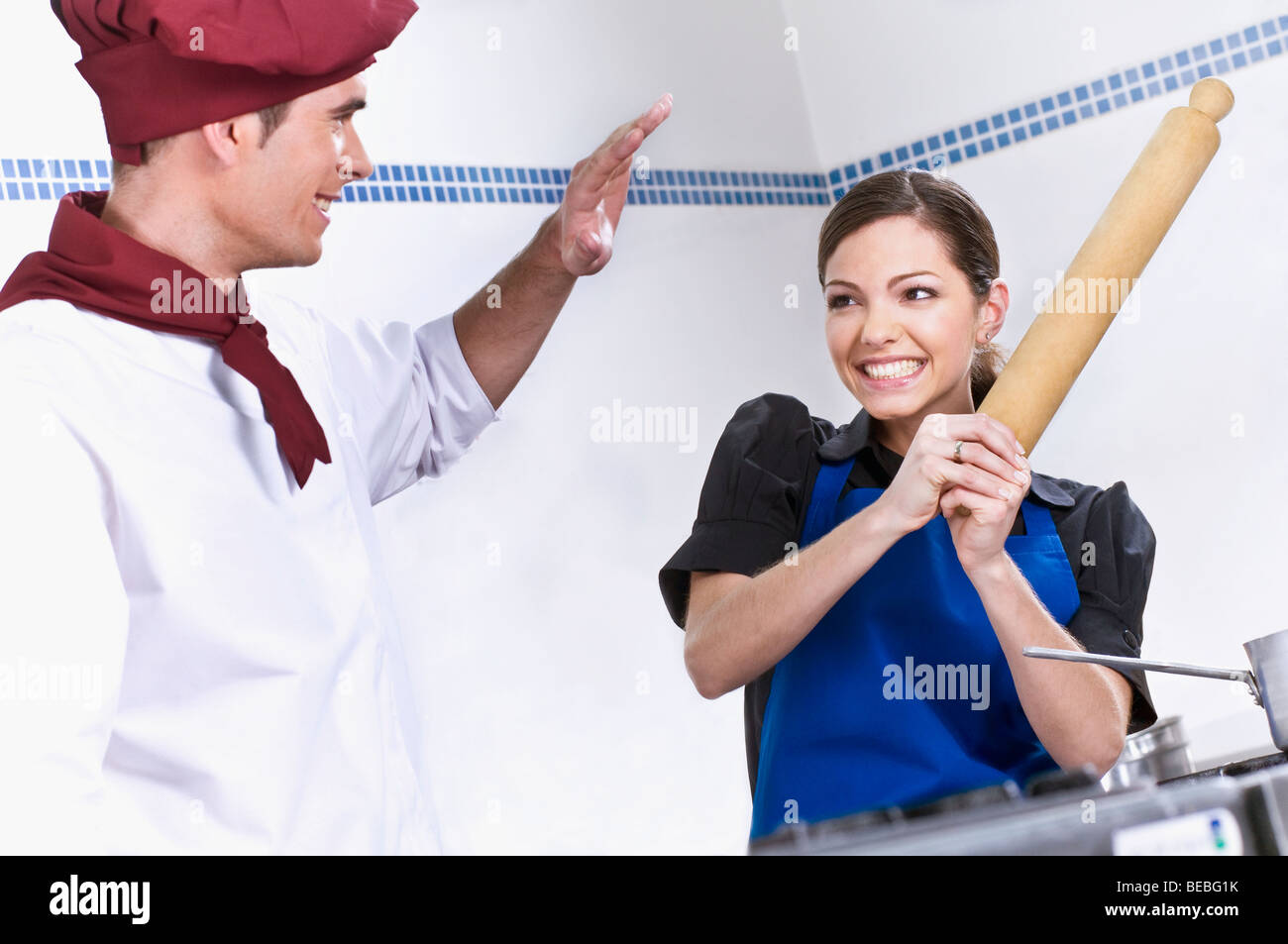 Female and a male chef having a play fight in the kitchen Stock Photo ...