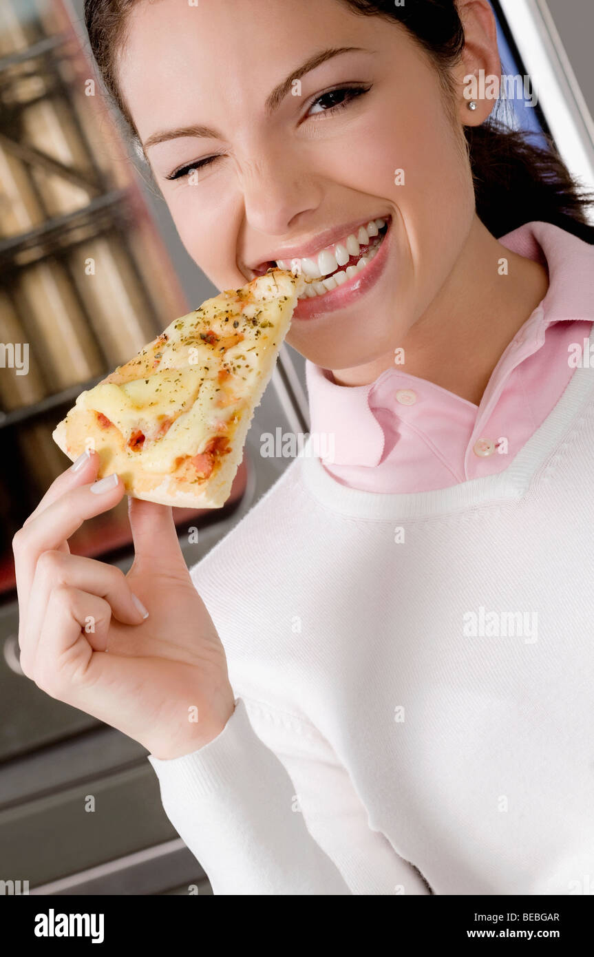Female chef eating a slice of pizza Stock Photo - Alamy