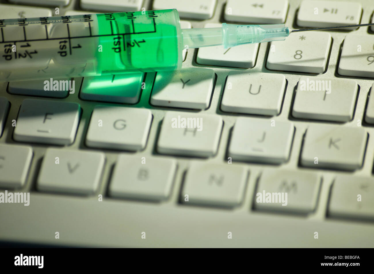 Syringe over keyboard Stock Photo - Alamy