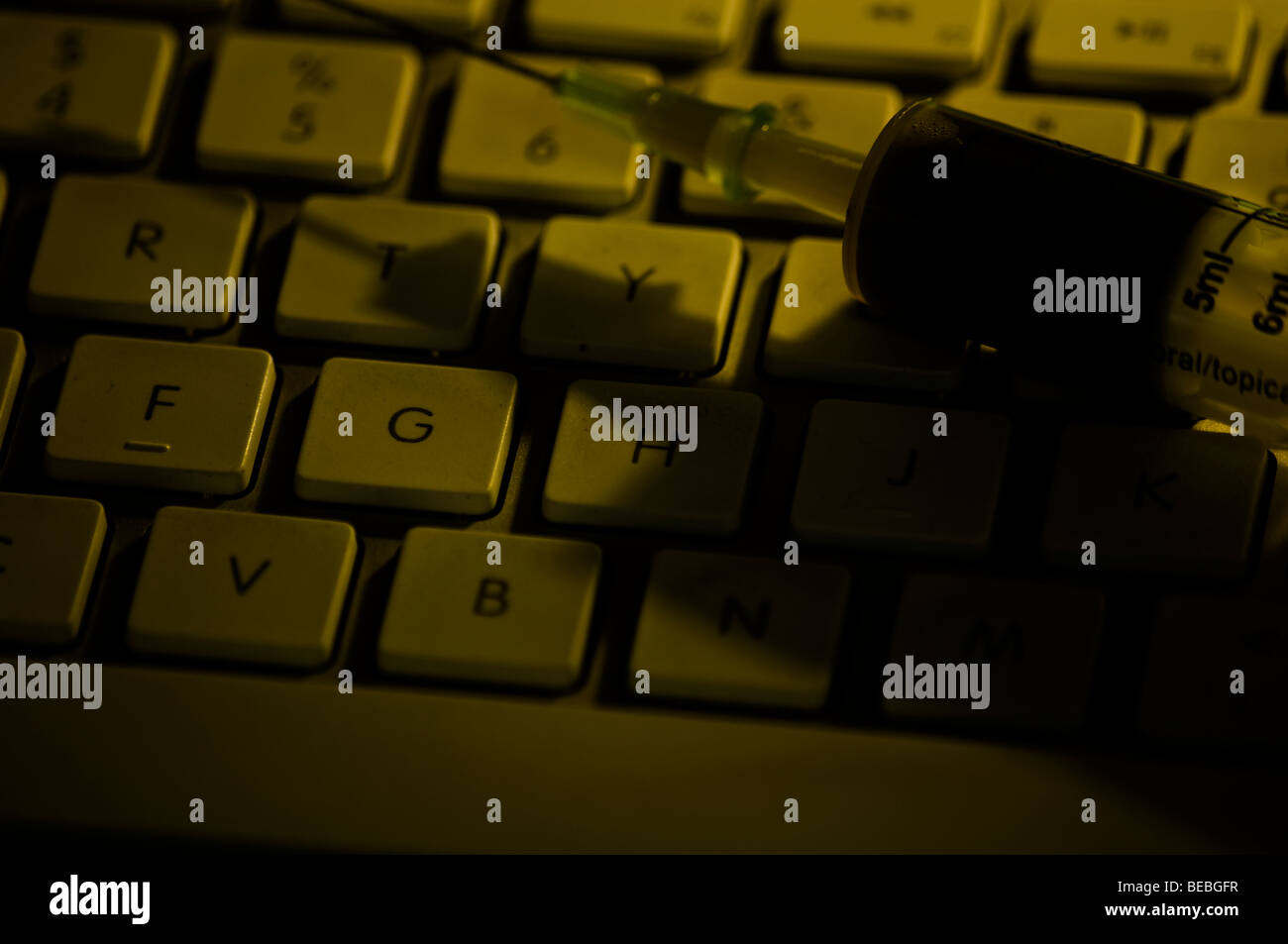 Syringe over keyboard Stock Photo - Alamy