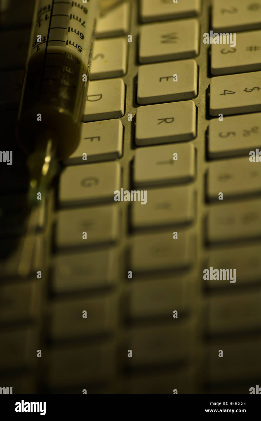 Syringe over keyboard Stock Photo - Alamy