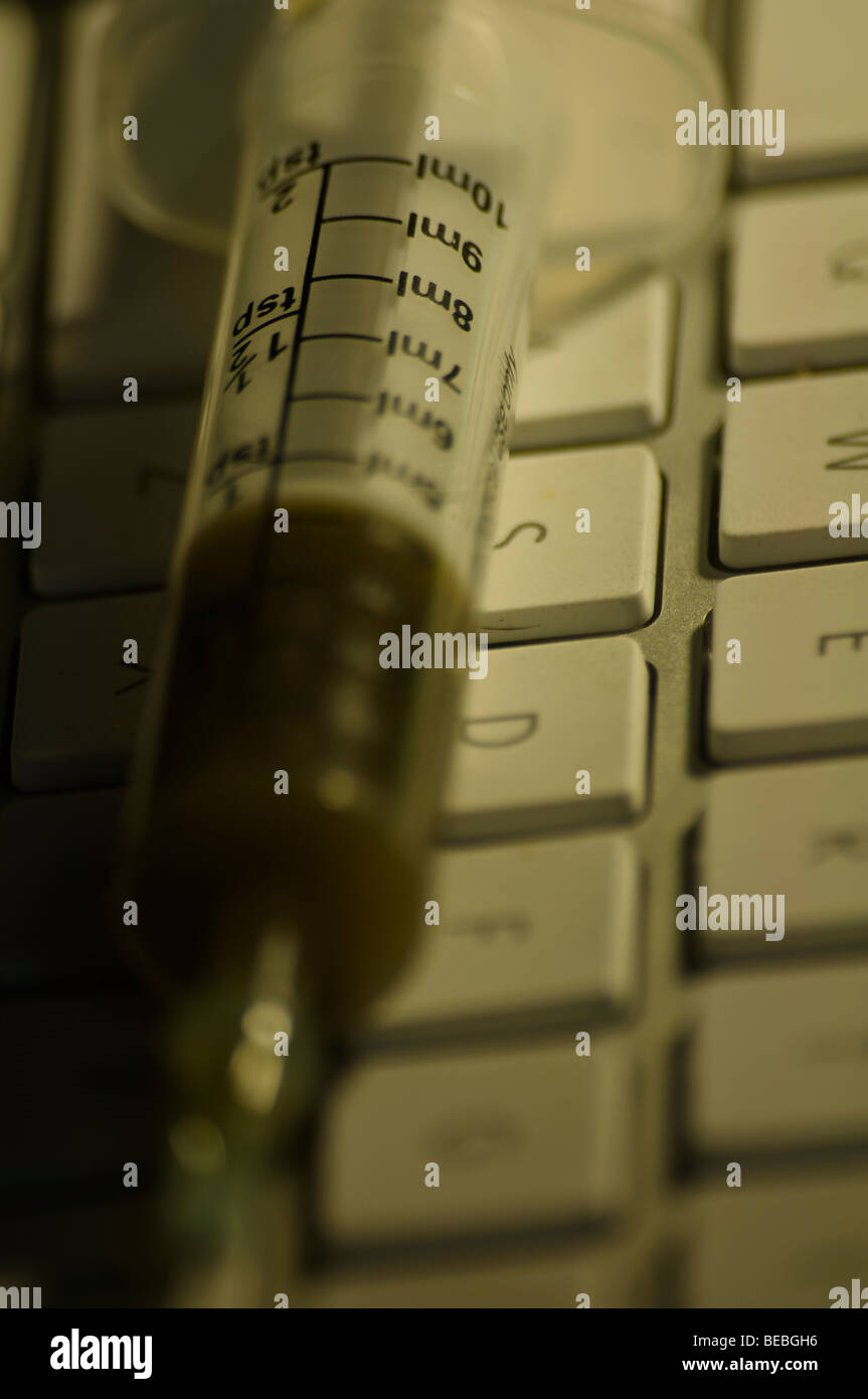 Syringe over keyboard Stock Photo - Alamy