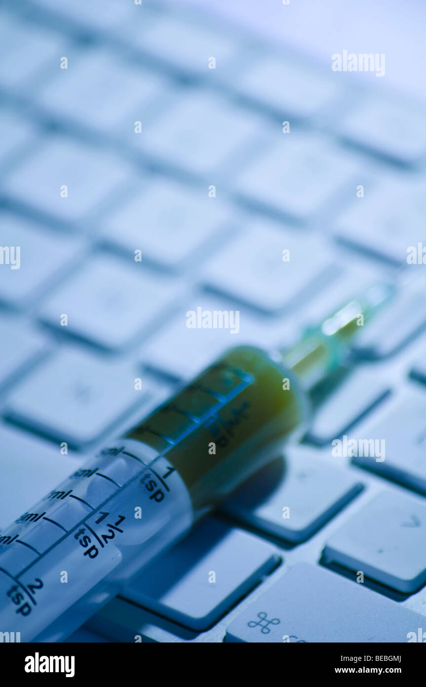 Syringe over keyboard Stock Photo - Alamy