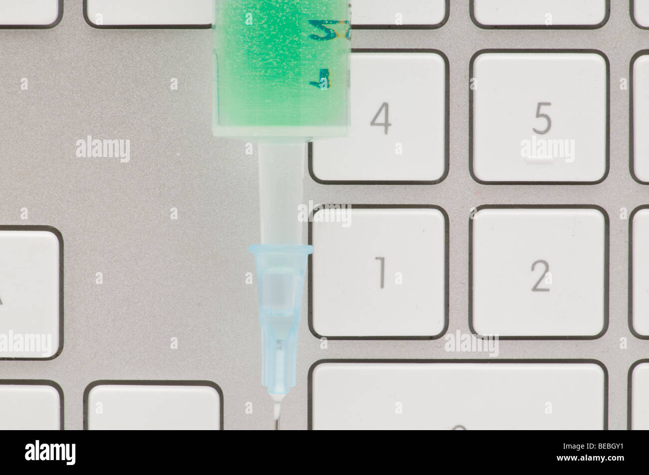 Syringe over keyboard Stock Photo - Alamy
