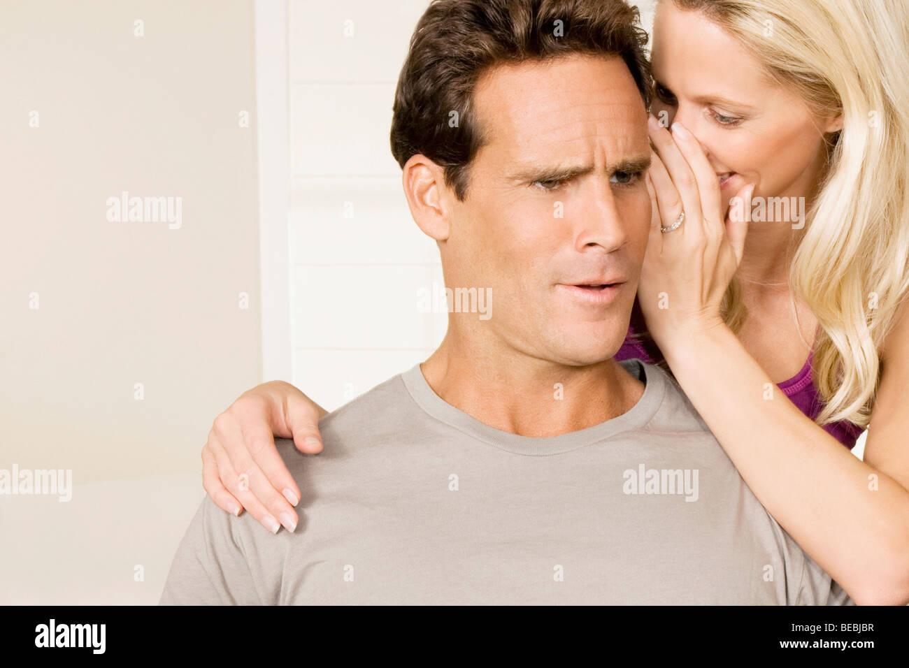 Woman whispering to a man Stock Photo - Alamy