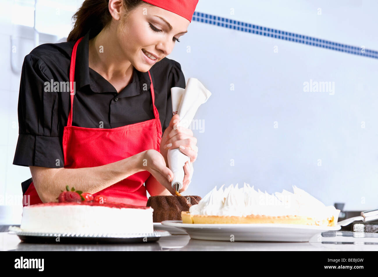 Female chef icing a cake Stock Photo - Alamy