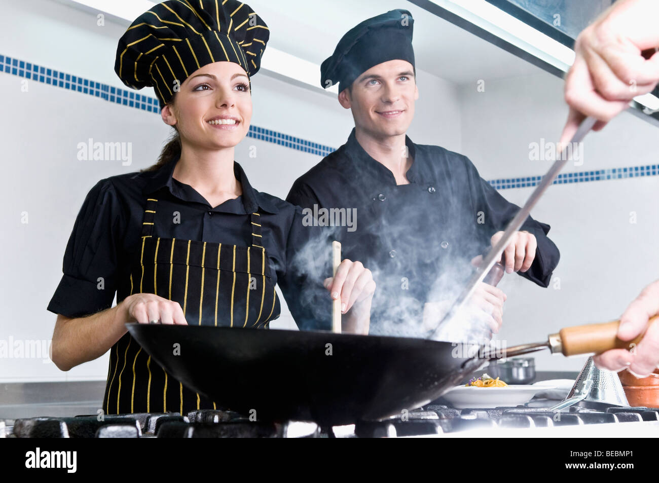 Female and a male chef cooking food in the kitchen Stock Photo - Alamy