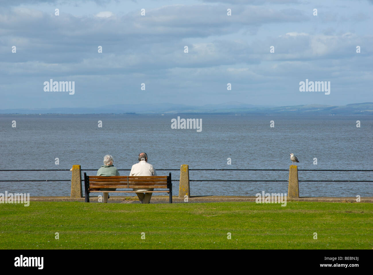 Couple sitting on bench at Silloth promenade, gazing over the Solway ...