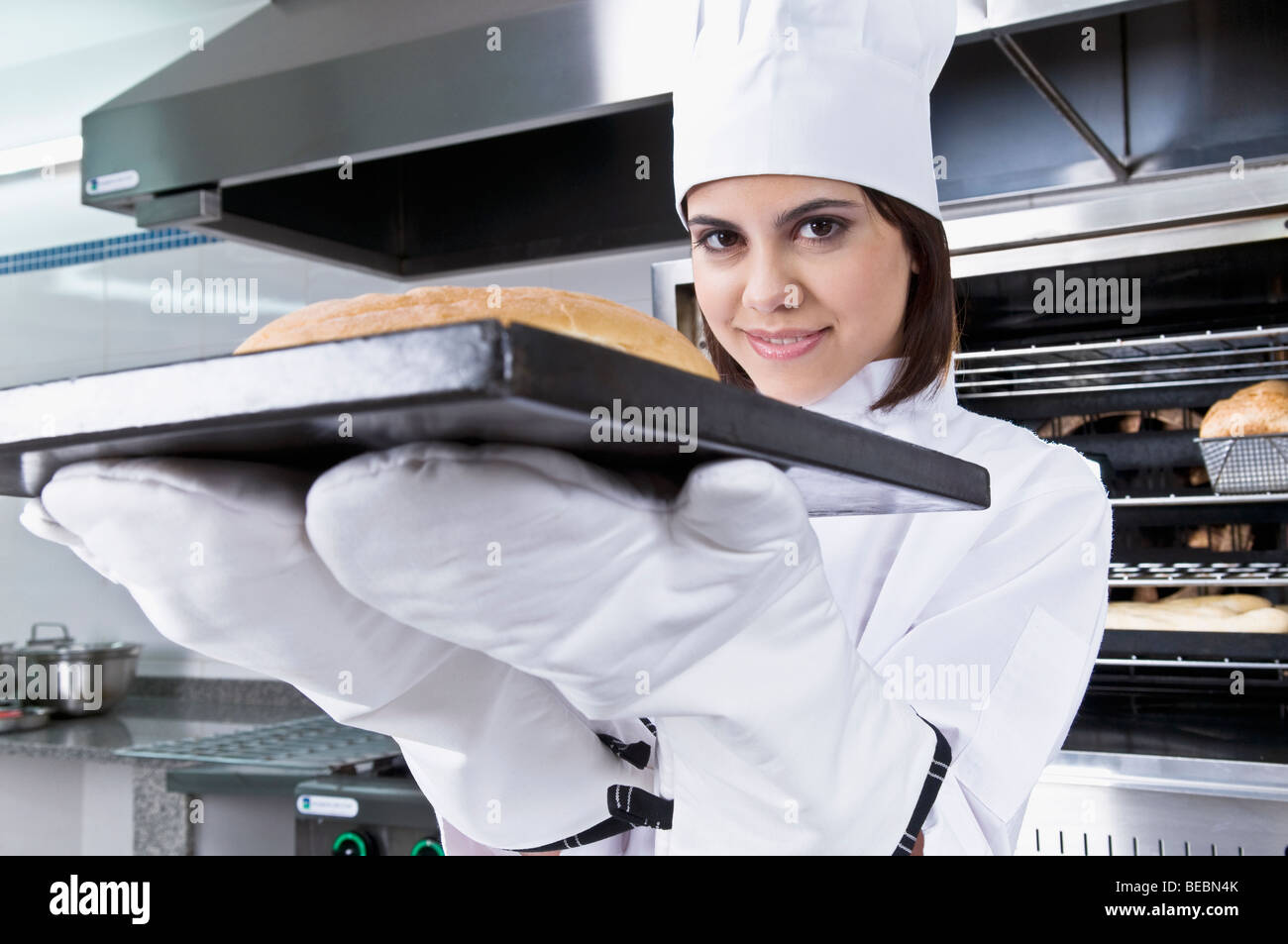 Female chef holding a bun in a tray Stock Photo - Alamy