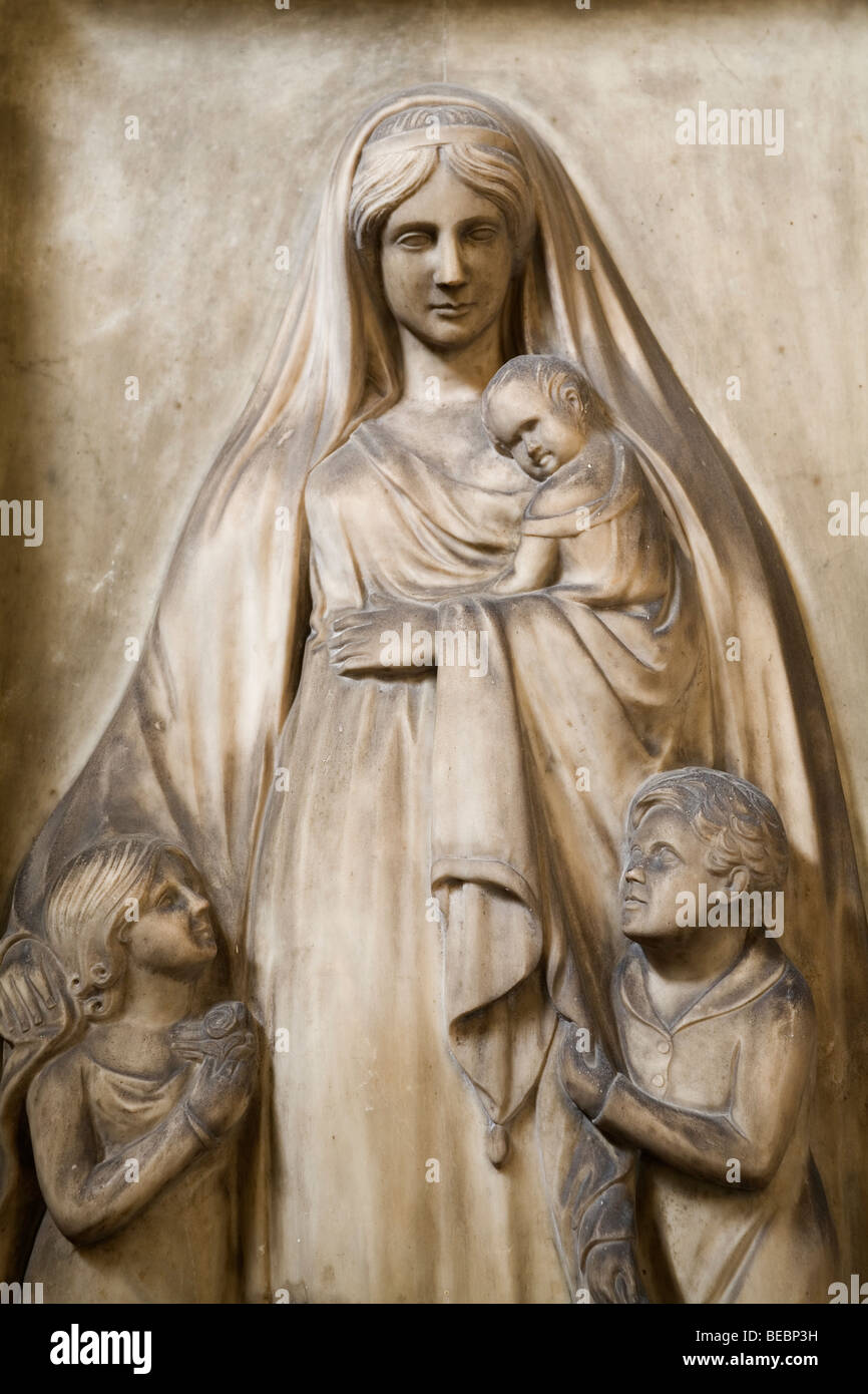 A bas-relief female figure with young children. The sculpture gives the ...