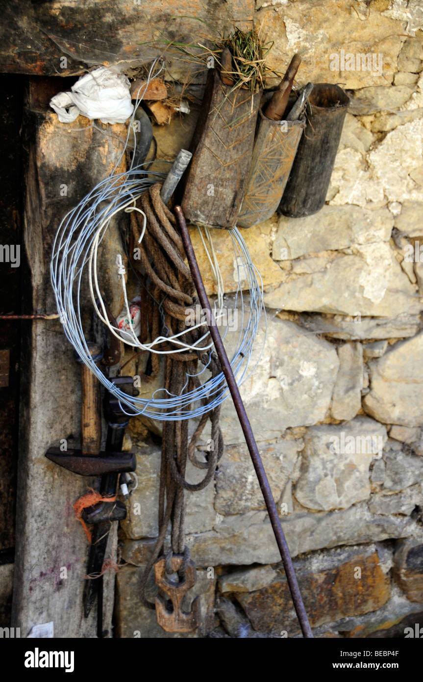 Traditional agricultural tools hanging from a stone wall in Asturias ...