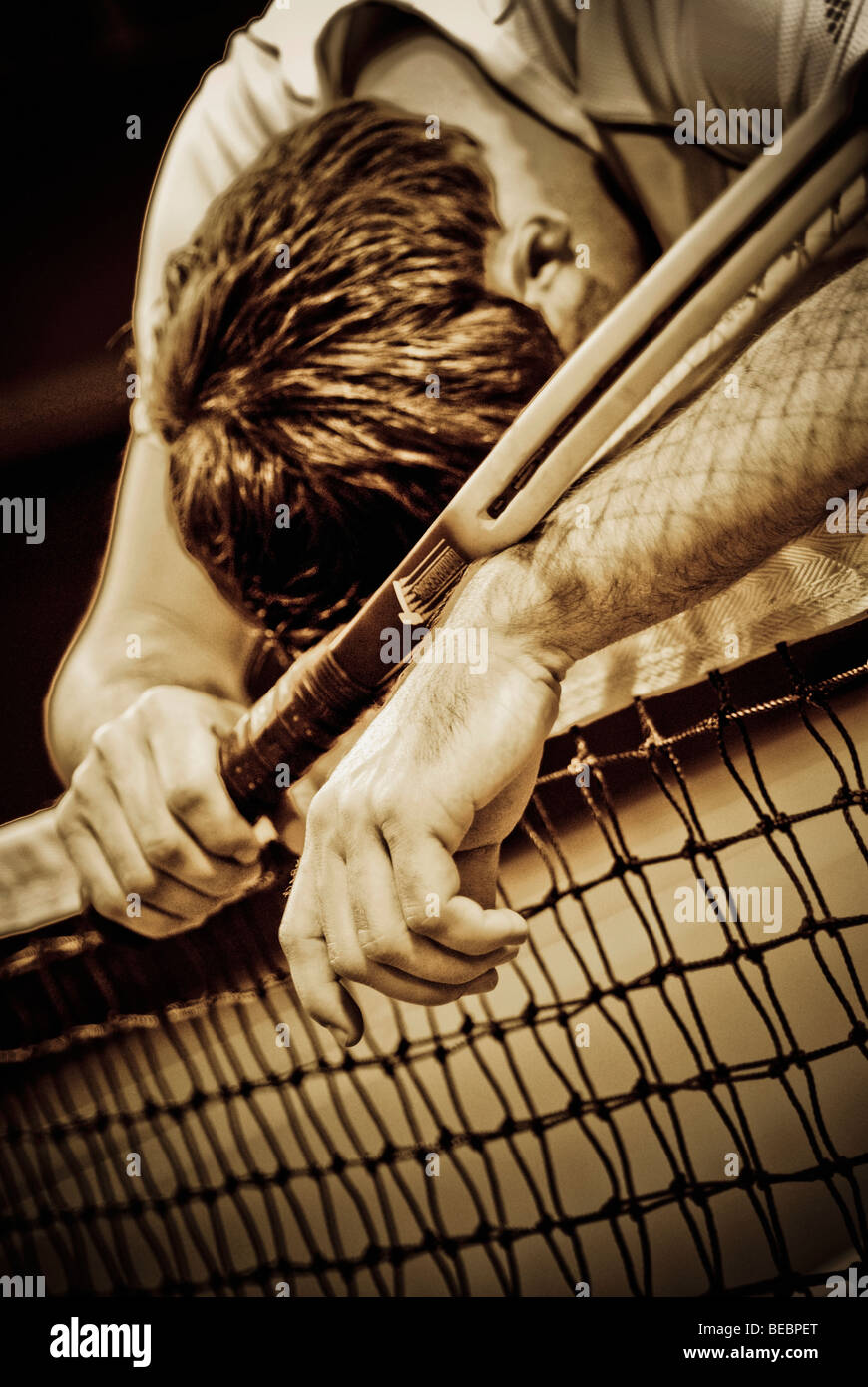 Tennis player leaning over a tennis net Stock Photo - Alamy