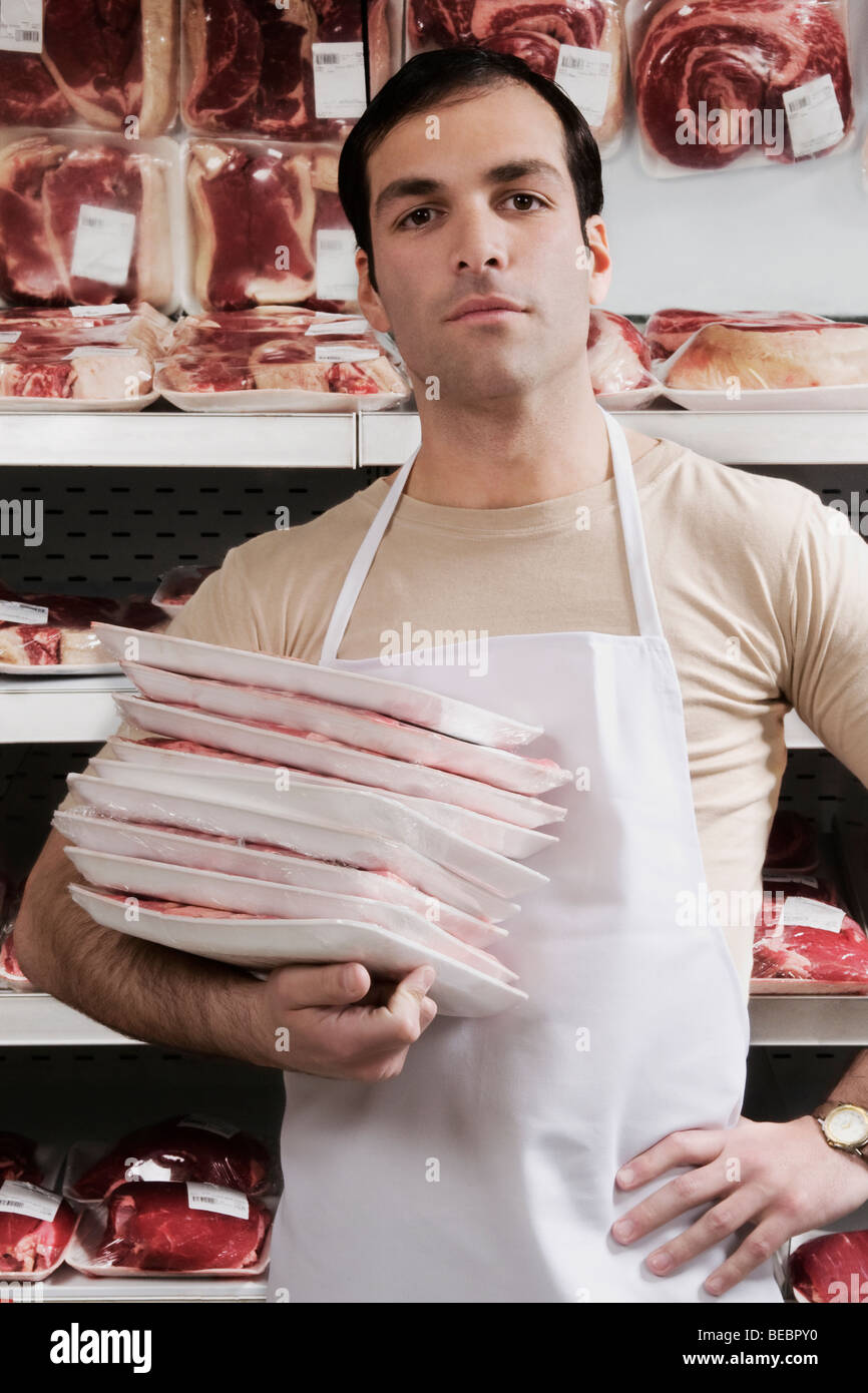 Portrait of a salesman holding meat packets Stock Photo - Alamy