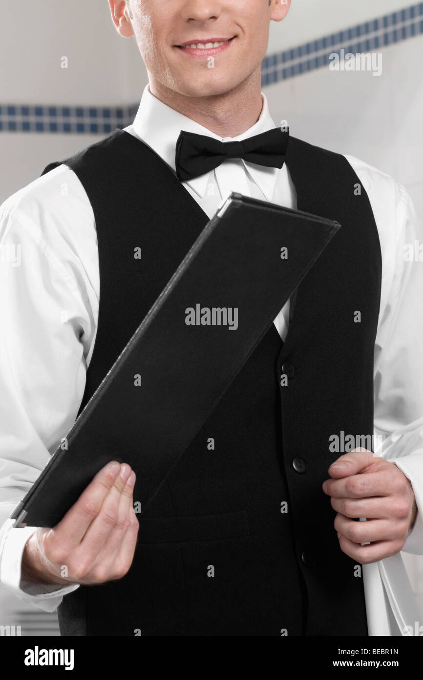 Waiter holding menu in a restaurant Stock Photo - Alamy