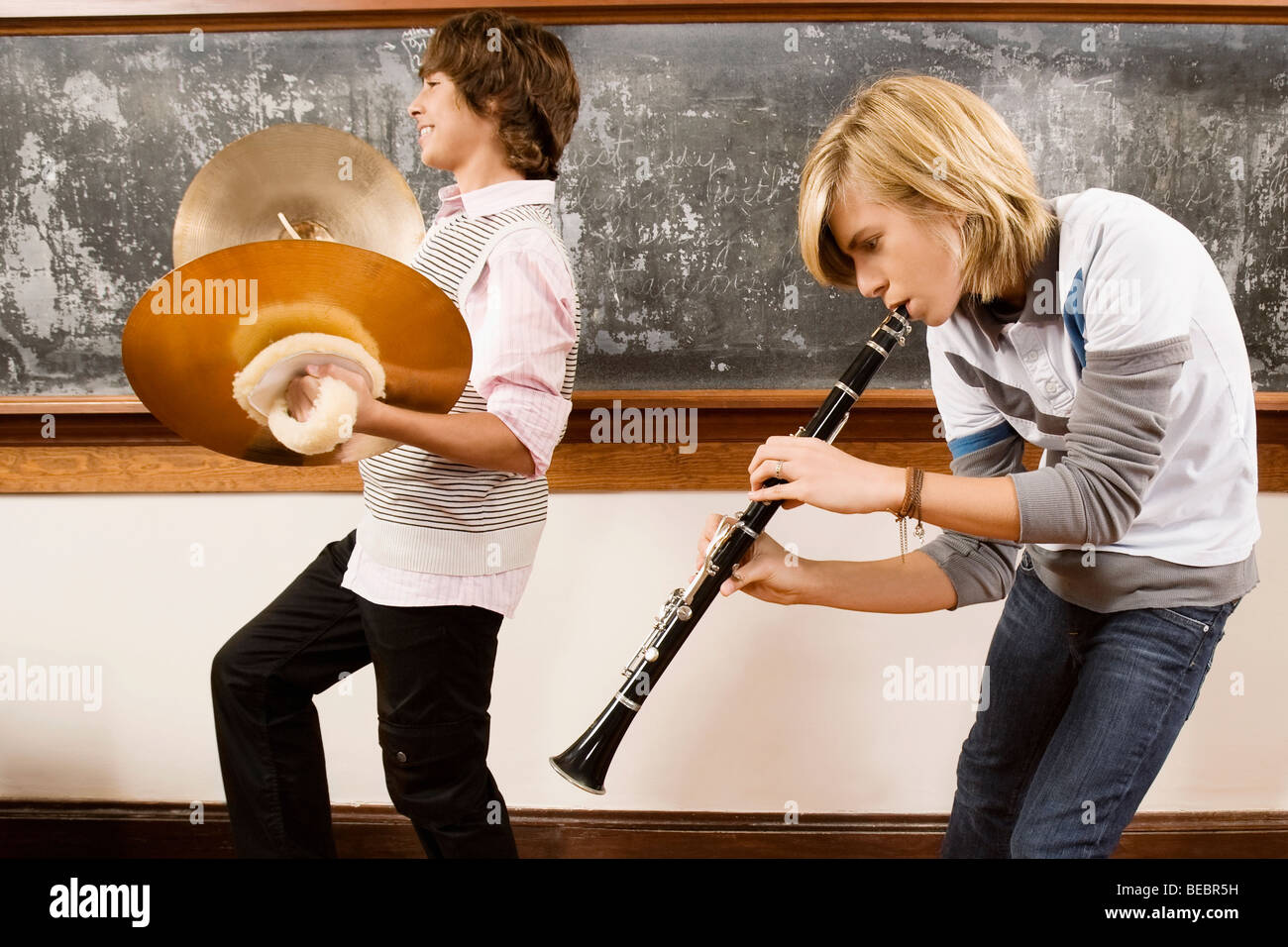Two teenage boys playing musical instruments in a classroom Stock Photo ...